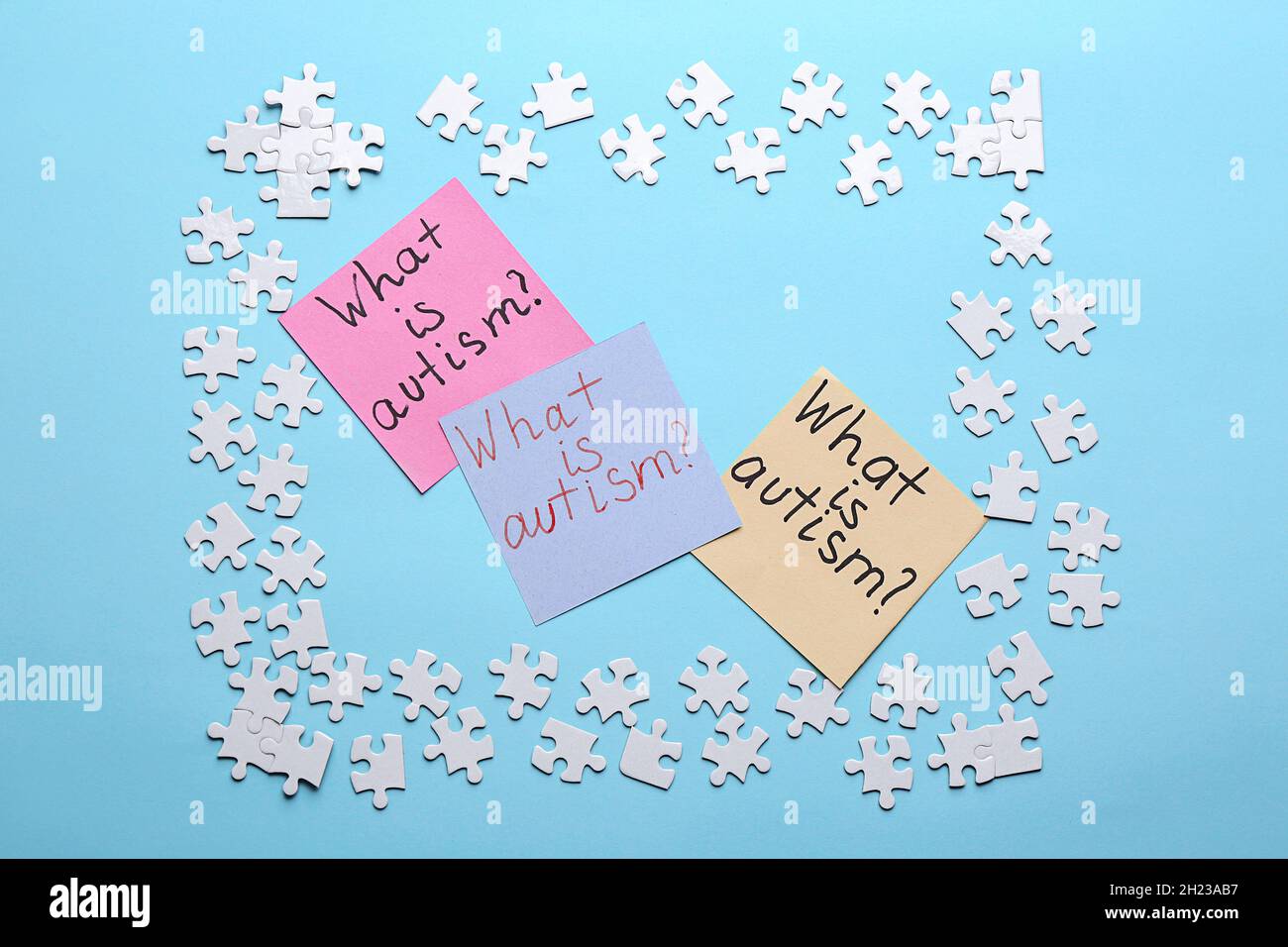Sticky notes with phrase "What is autism?" and puzzle pieces on color ...