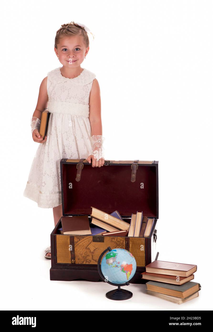 girl and a chest with books. little girl looking inside a trunk with ...