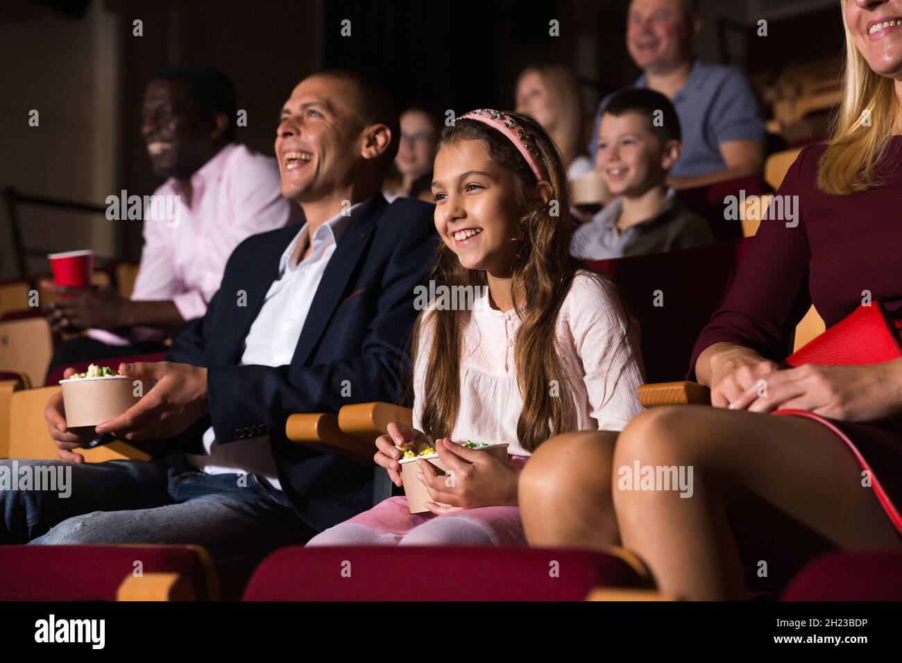 Family with child eating popcorn and watching movie in the cinema Stock ...