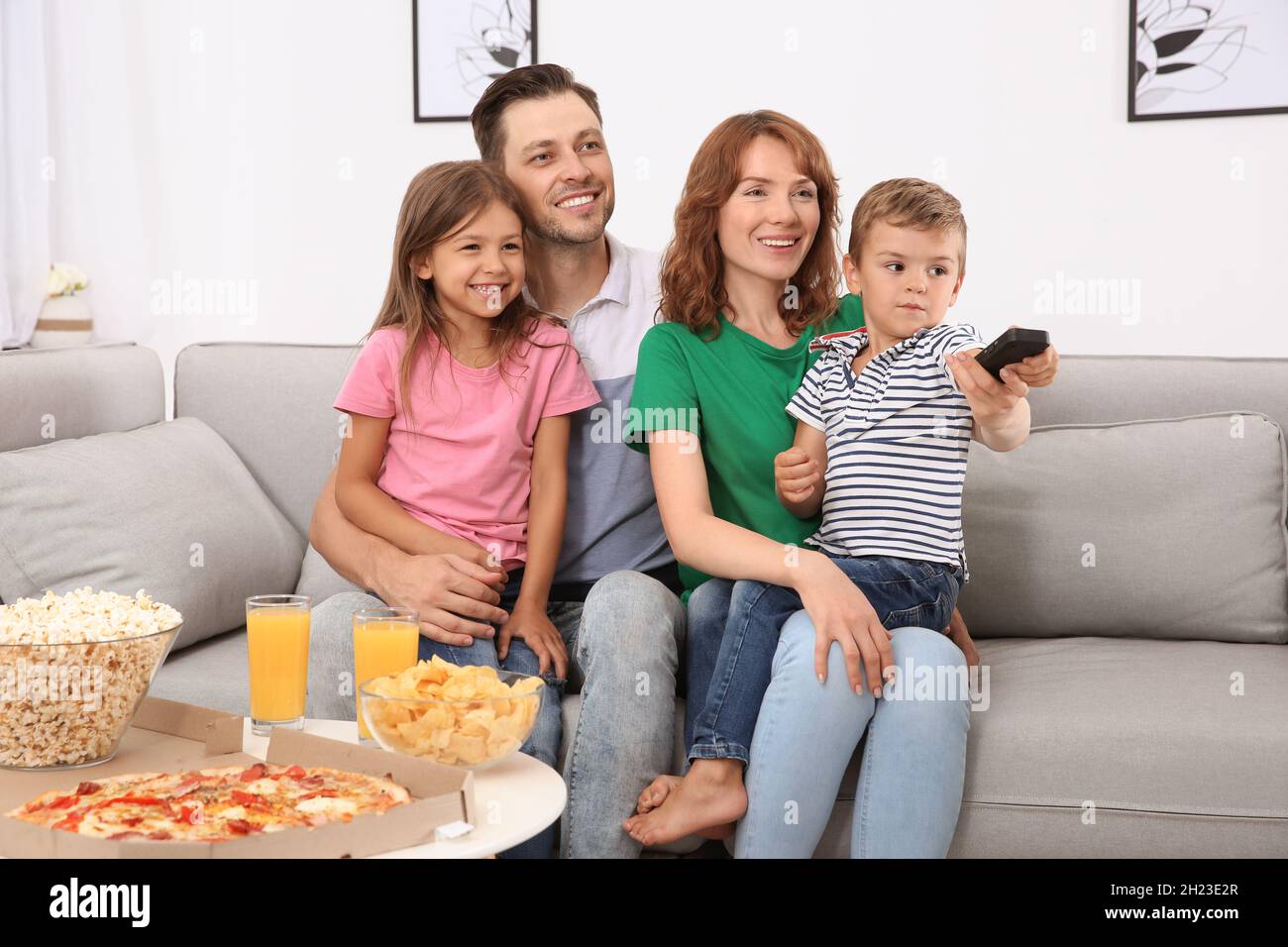 Family watching TV in room at home Stock Photo - Alamy
