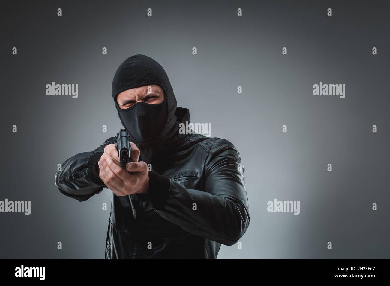 Robber with a gun, studio shot Stock Photo - Alamy