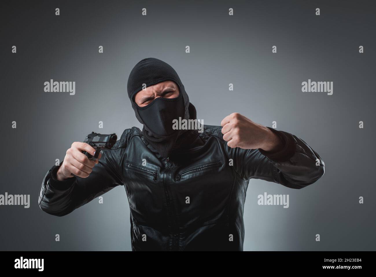 Masked robber with gun, looking into the camera Stock Photo - Alamy