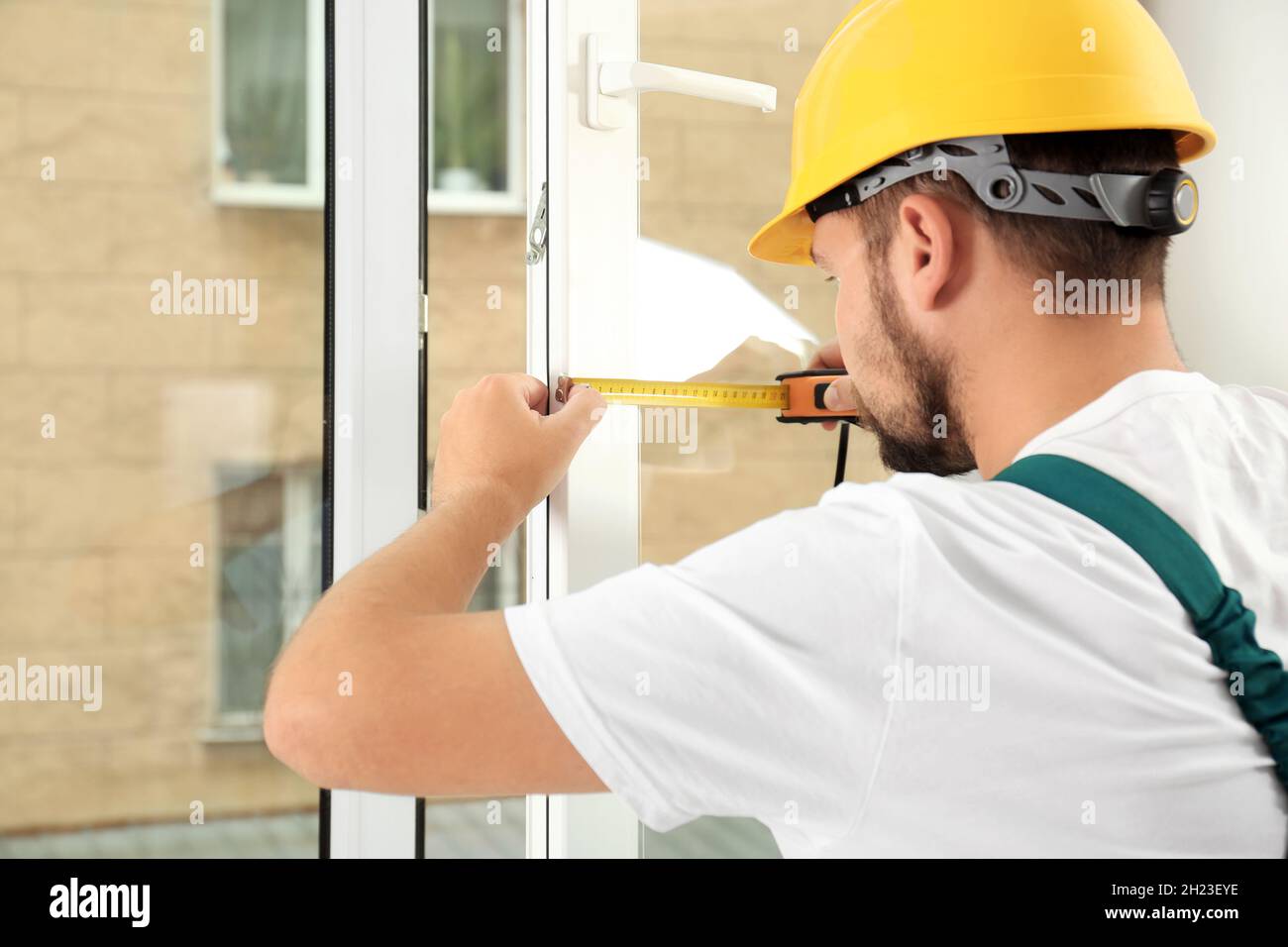 Construction worker installing new window in house Stock Photo - Alamy