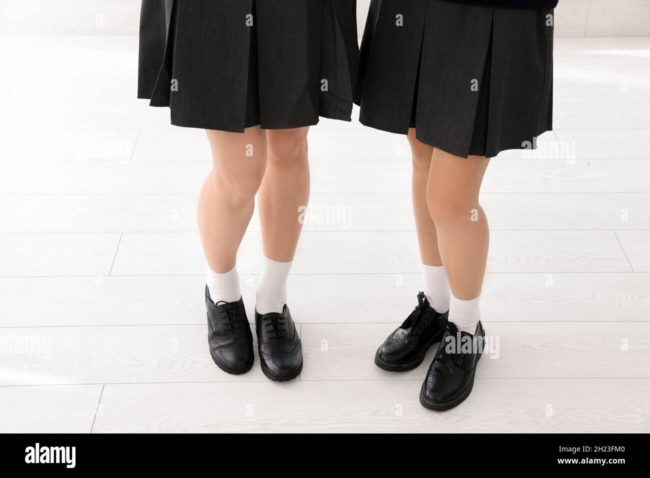 Girls in stylish school uniform indoors, focus on legs Stock Photo - Alamy