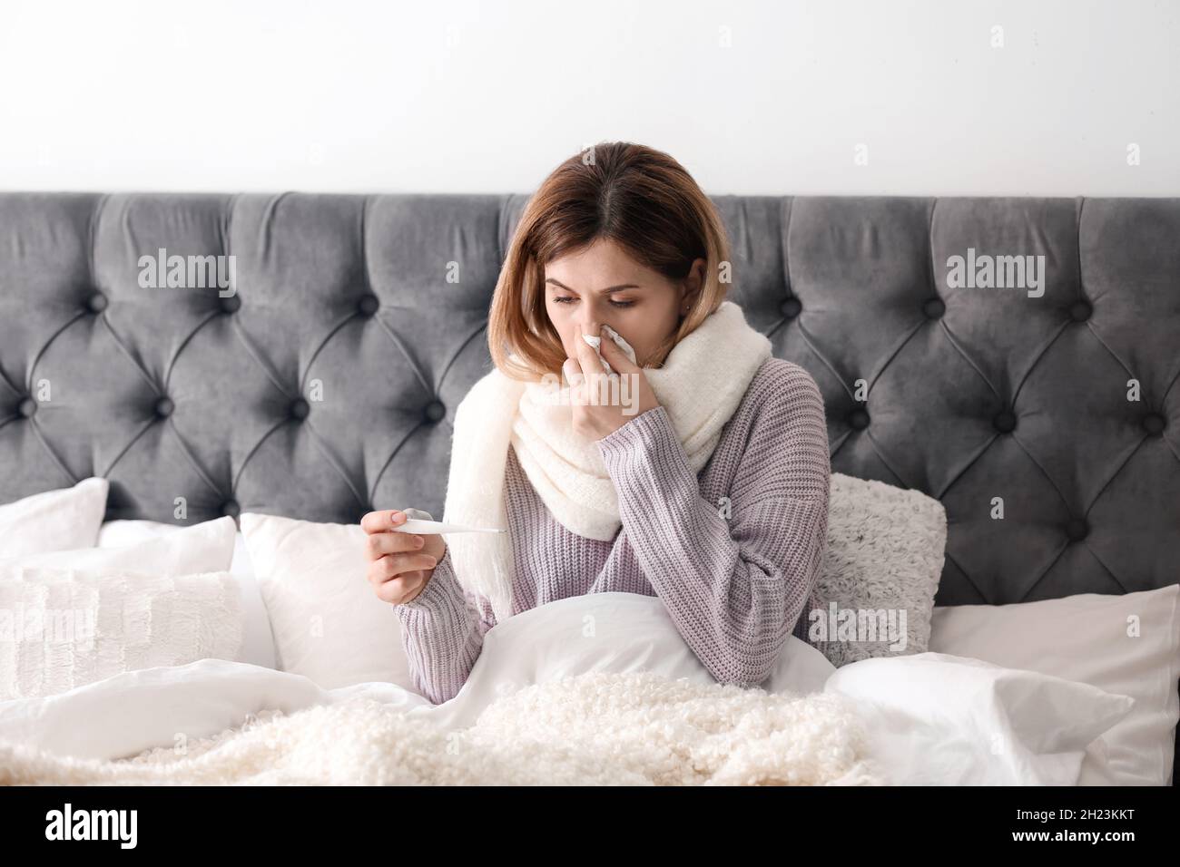 Sick woman with tissue and thermometer suffering from cold in bed Stock ...