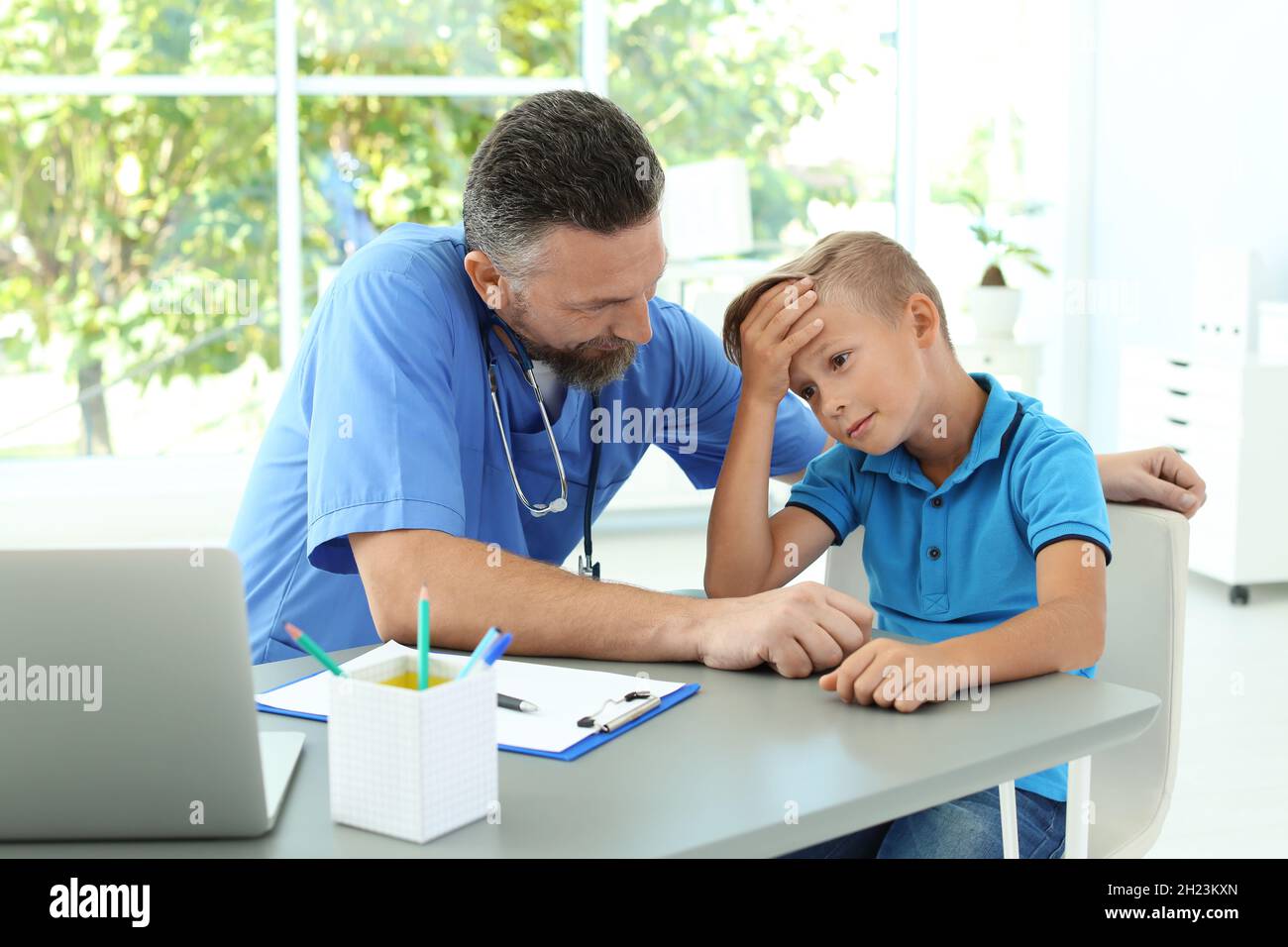 Male medical assistant consulting child in clinic Stock Photo - Alamy