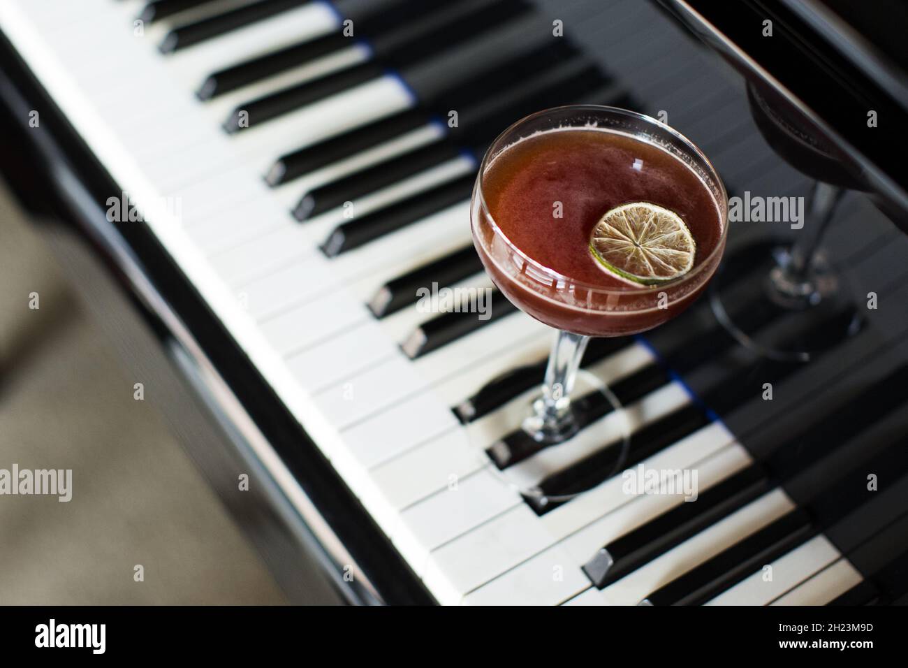 Glass of alcoholic cocktail on the background of a piano Stock Photo ...