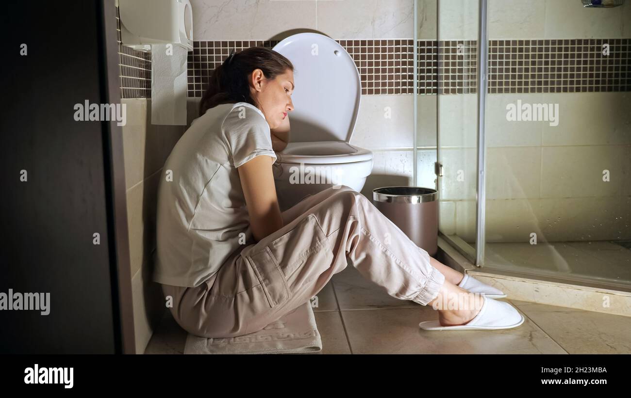 Woman sitting on toilet hi-res stock photography and images - Alamy