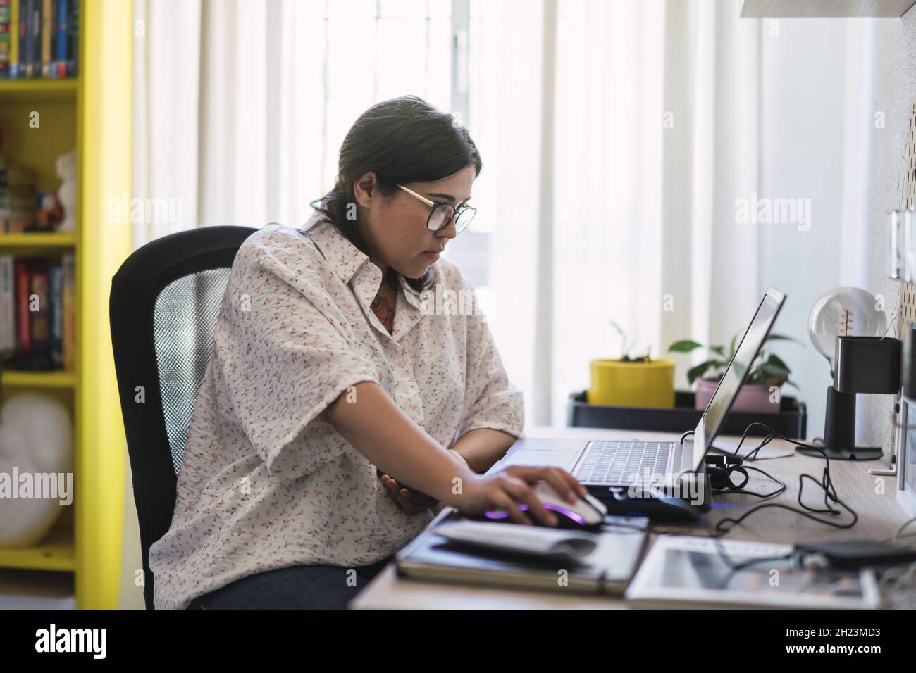 Young woman working on her computer at the desk in her room Stock Photo ...
