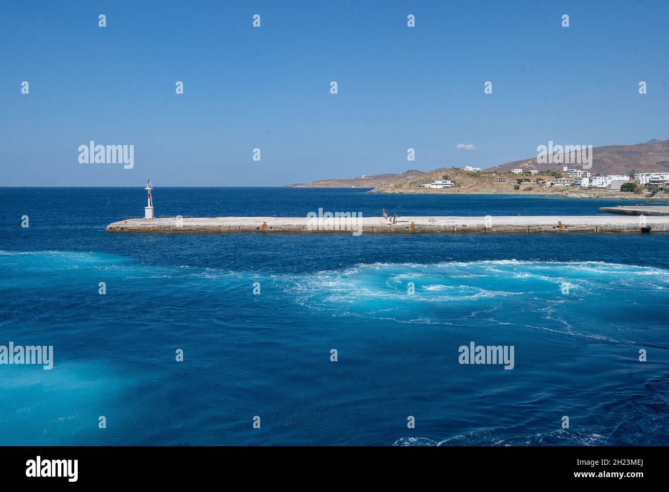 The main dock and its lighthouse at the port of Tinos island,Greece ...