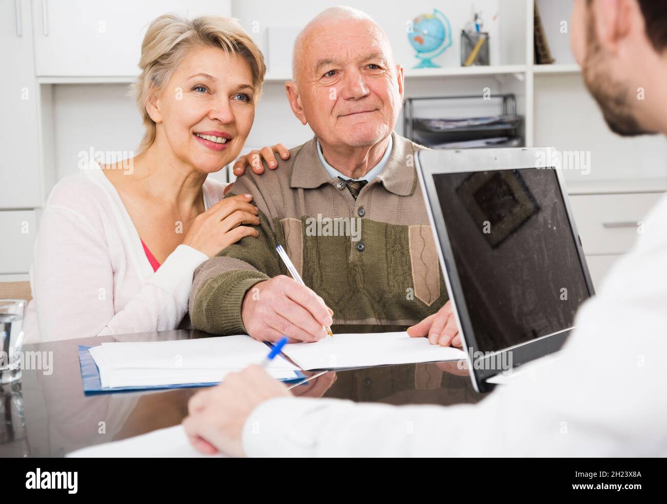 couple signing papers in bank Stock Photo - Alamy