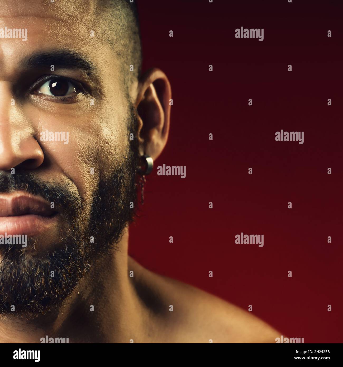 Face with a beard and an earring in the ear of a Cuban man close-up ...