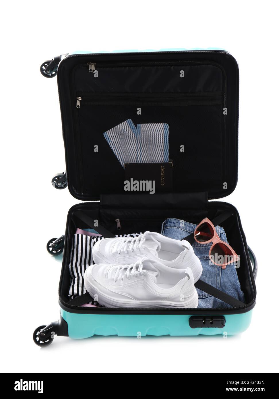 Open suitcase packed for travelling on white background Stock Photo - Alamy
