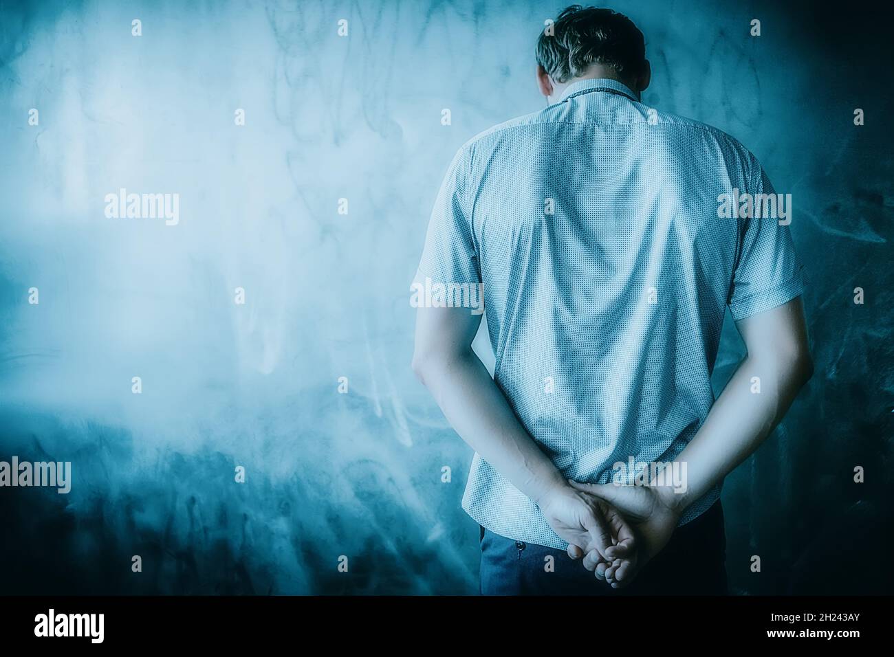 The man rested his head against the wall. Standing facing the wall. The ...