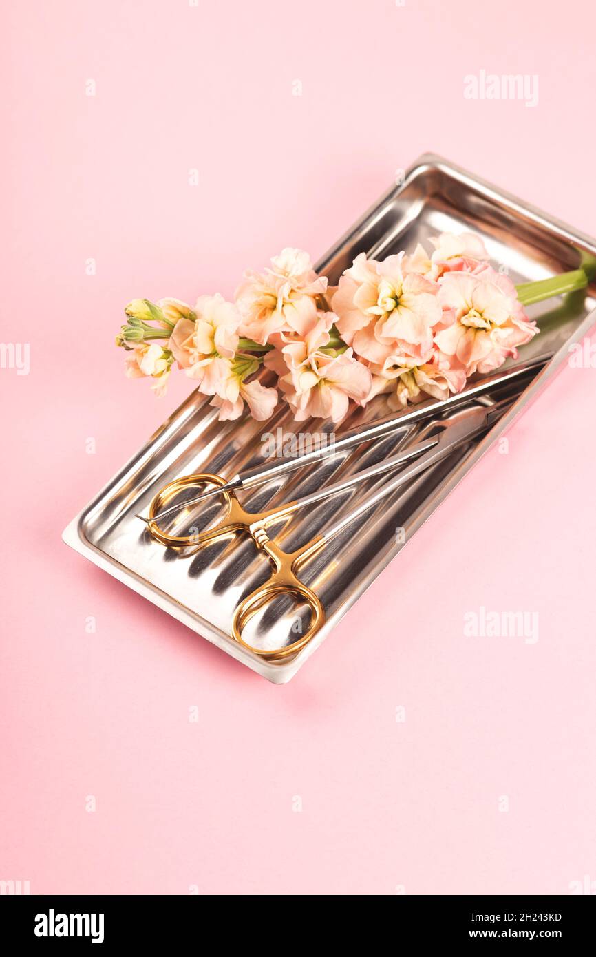 Dentist tools on metal tray with flowers on pink background. Dental ...