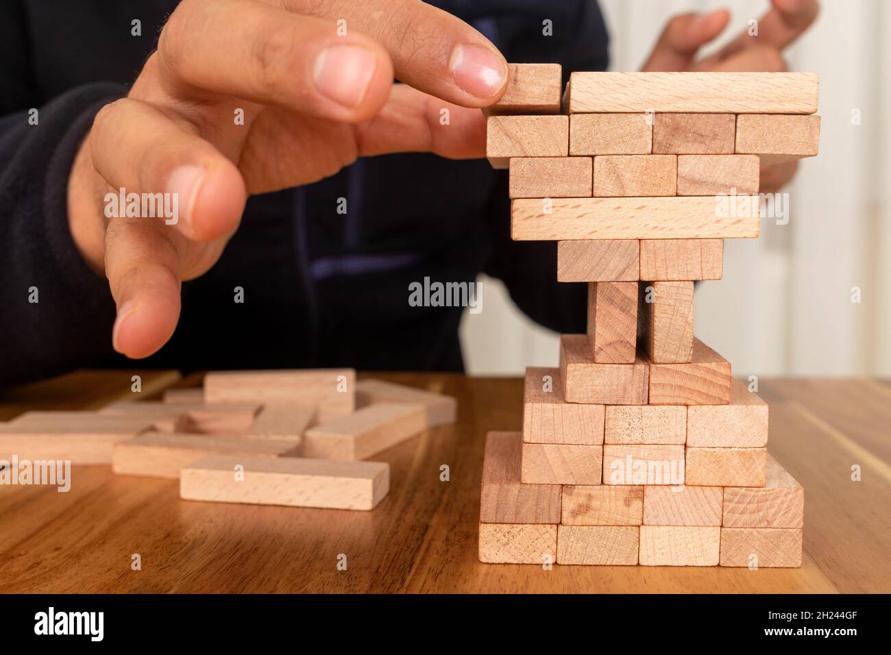 Man building wooden blocks shape of hour glass. Business and time ...