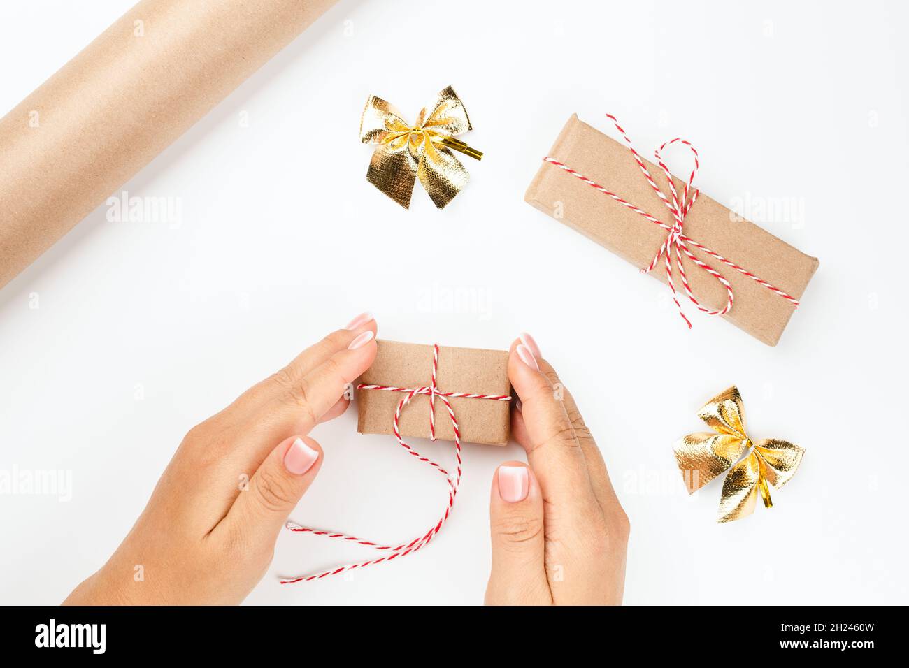 flat lay on hands tying a red thread on Christmas gift package ...