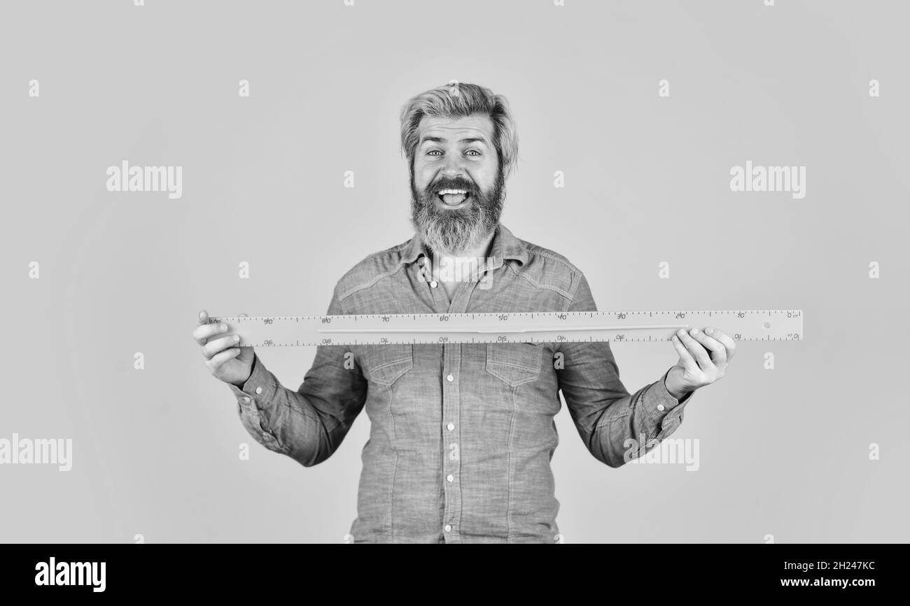 school lesson items. mature bearded man hold measuring ruler. study at ...