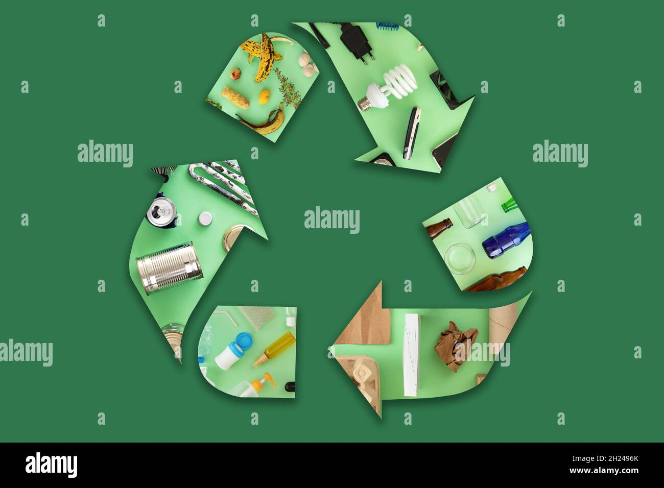 Recycling icon mocked up of different types of waste materials on green ...