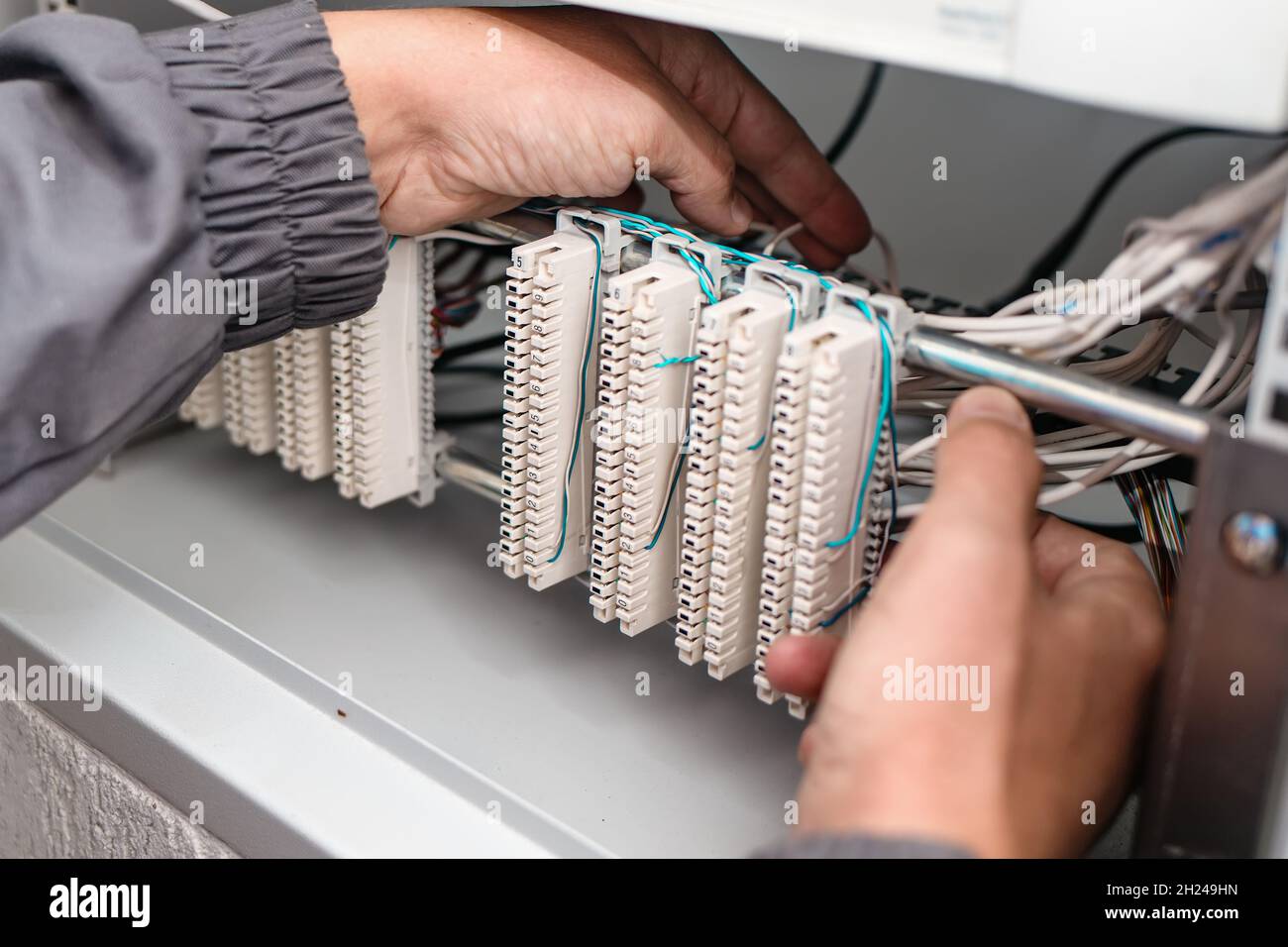 A man electrician checks the terminals of telephone communication ...