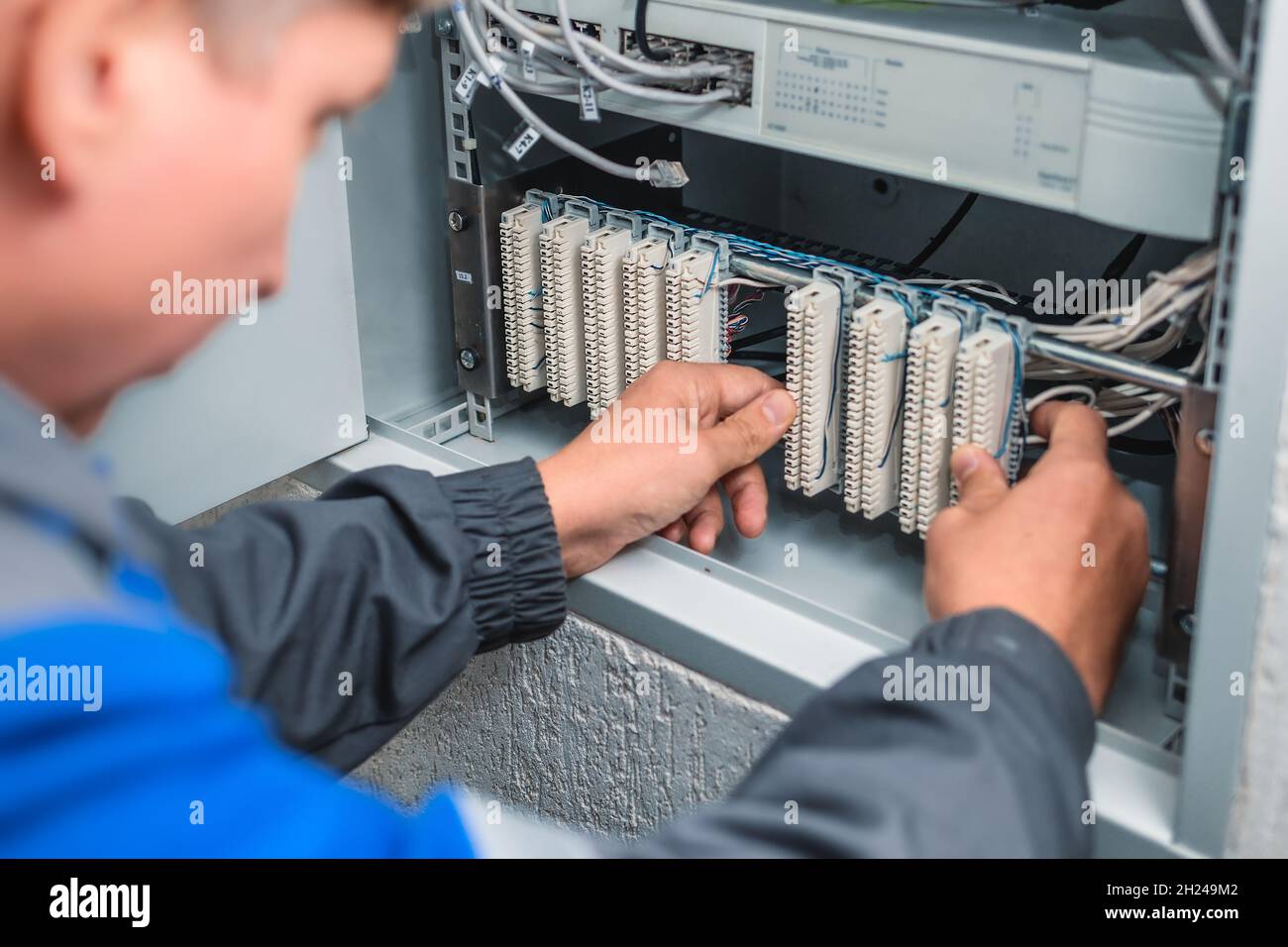 A man electrician checks the terminals of telephone communication ...