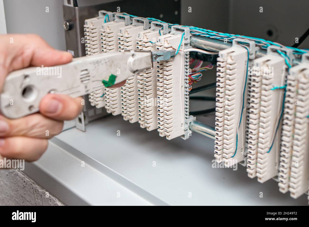 A man electrician checks the terminals of telephone communication ...