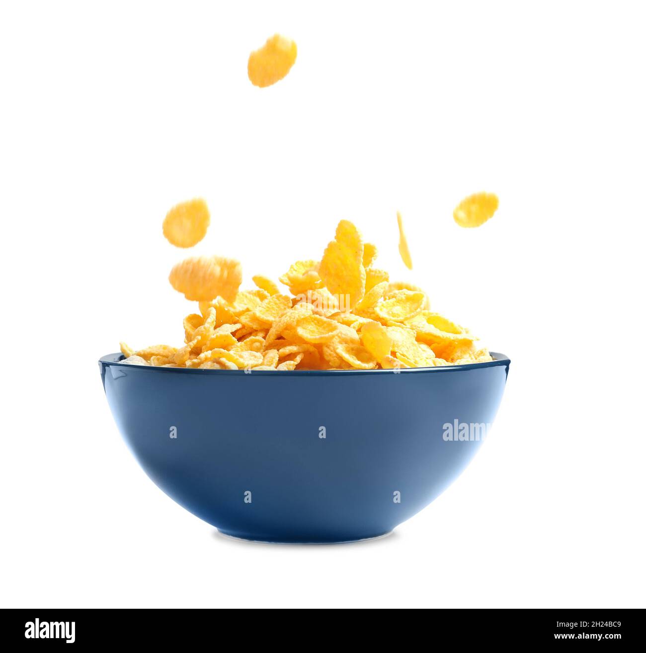 Crispy cornflakes falling into bowl on white background Stock Photo - Alamy