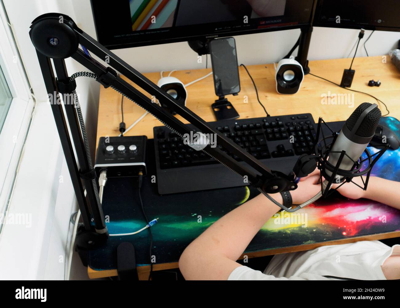 A young gamer with headphones boy playing a computer game on a powerful ...