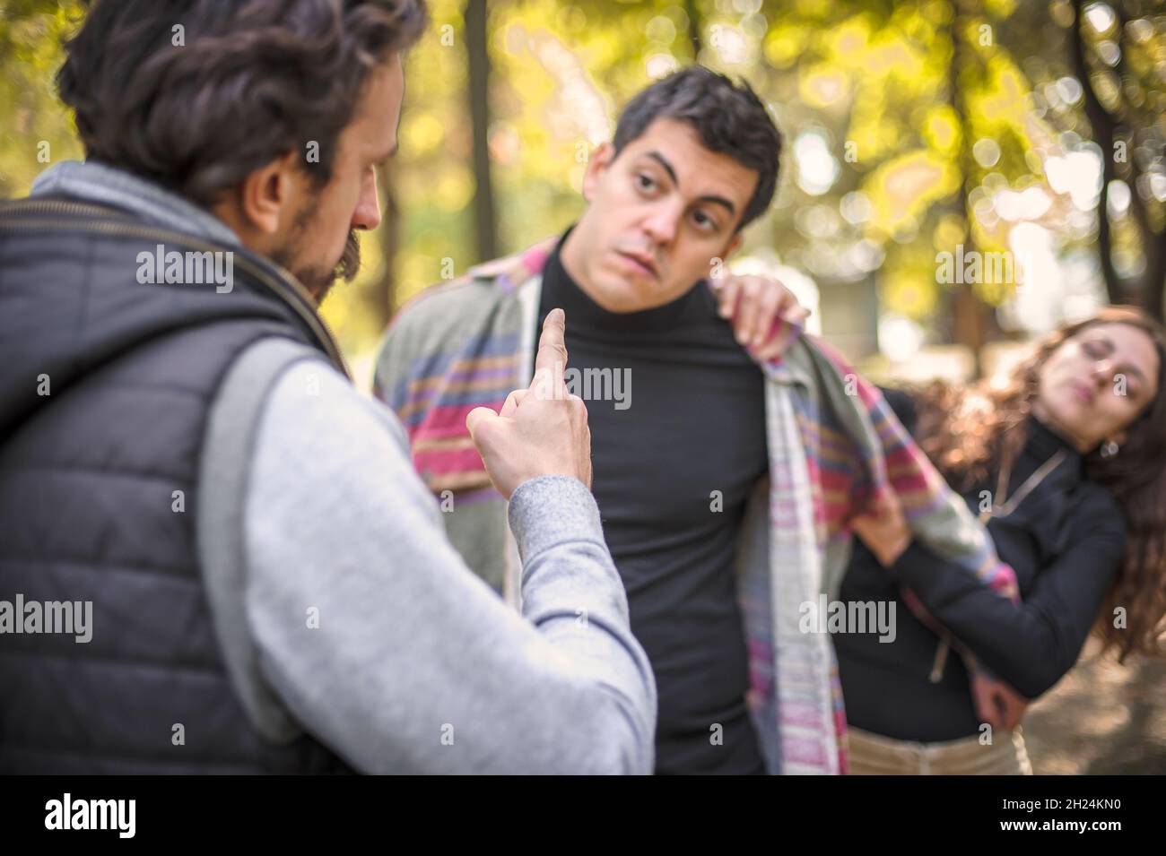 Two aggressive, angry, nervous and upset men in a quarrel and a woman ...