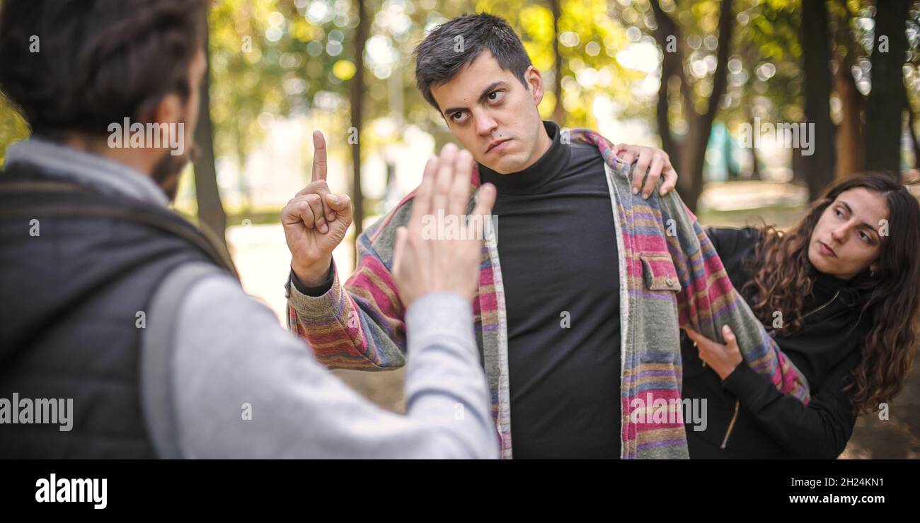 Two aggressive, angry, nervous and upset men in a quarrel and a woman ...