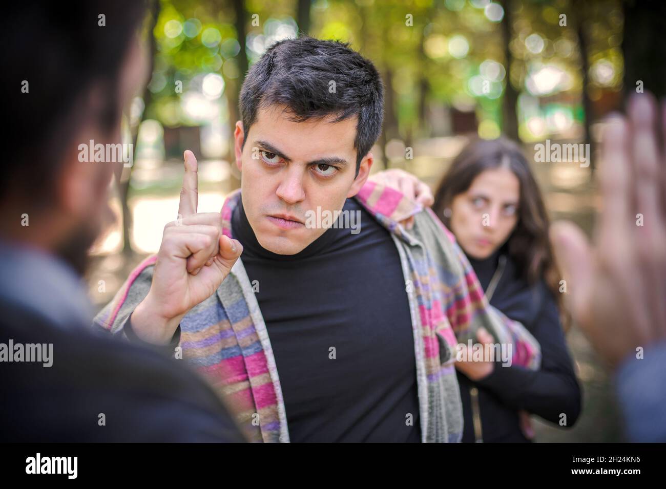 Two aggressive, angry, nervous and upset men in a quarrel and a woman ...