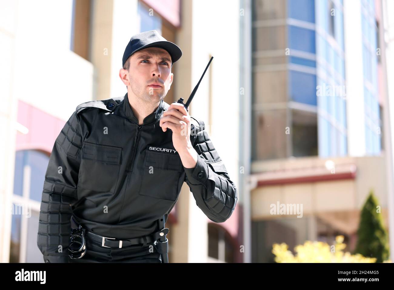 Male security guard using portable radio transmitter outdoors Stock ...