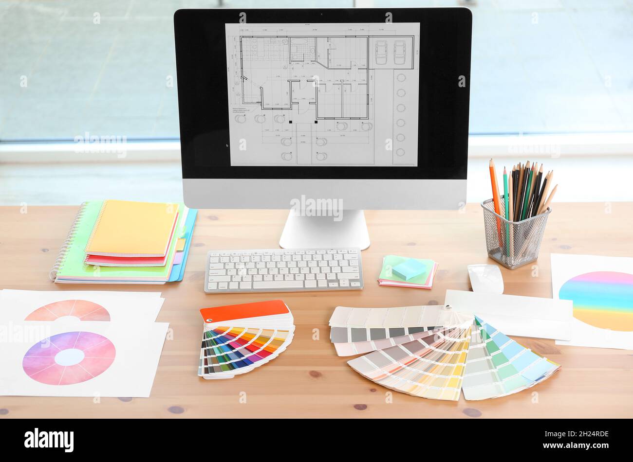 Designer's workplace with computer and paint color palette samples on ...