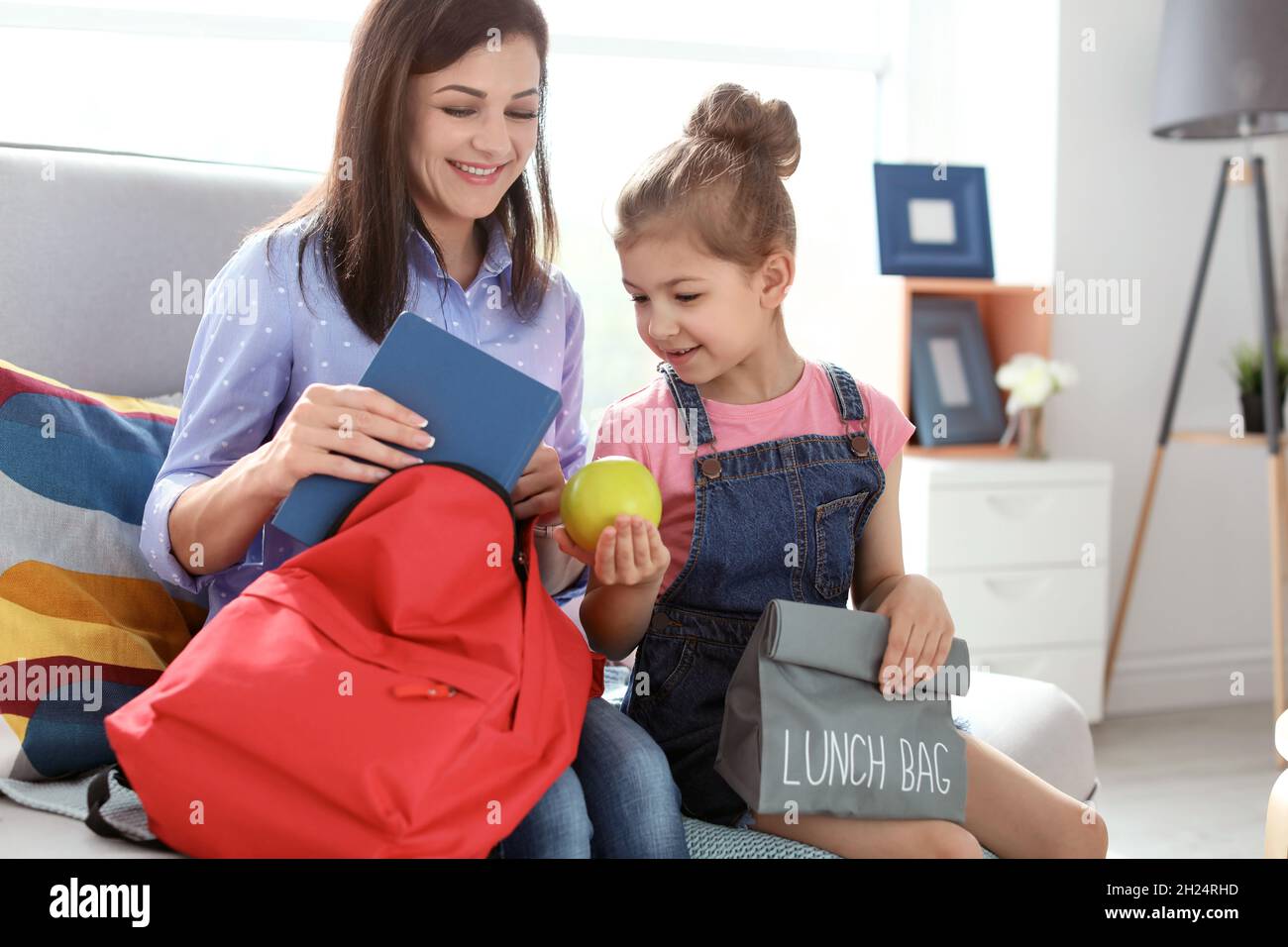 Young woman helping her little child get ready for school at home Stock ...