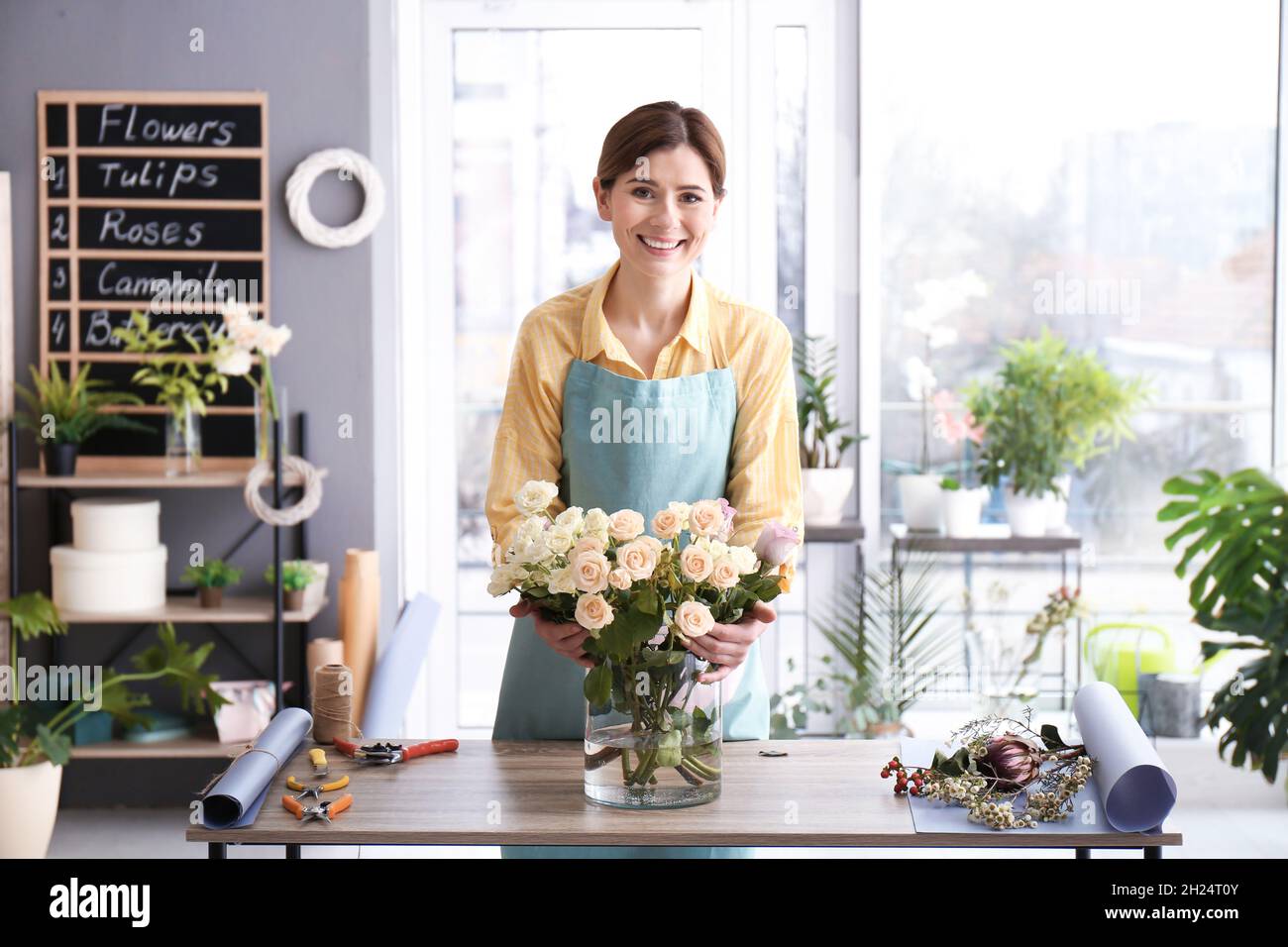 Female florist with roses at workplace Stock Photo - Alamy