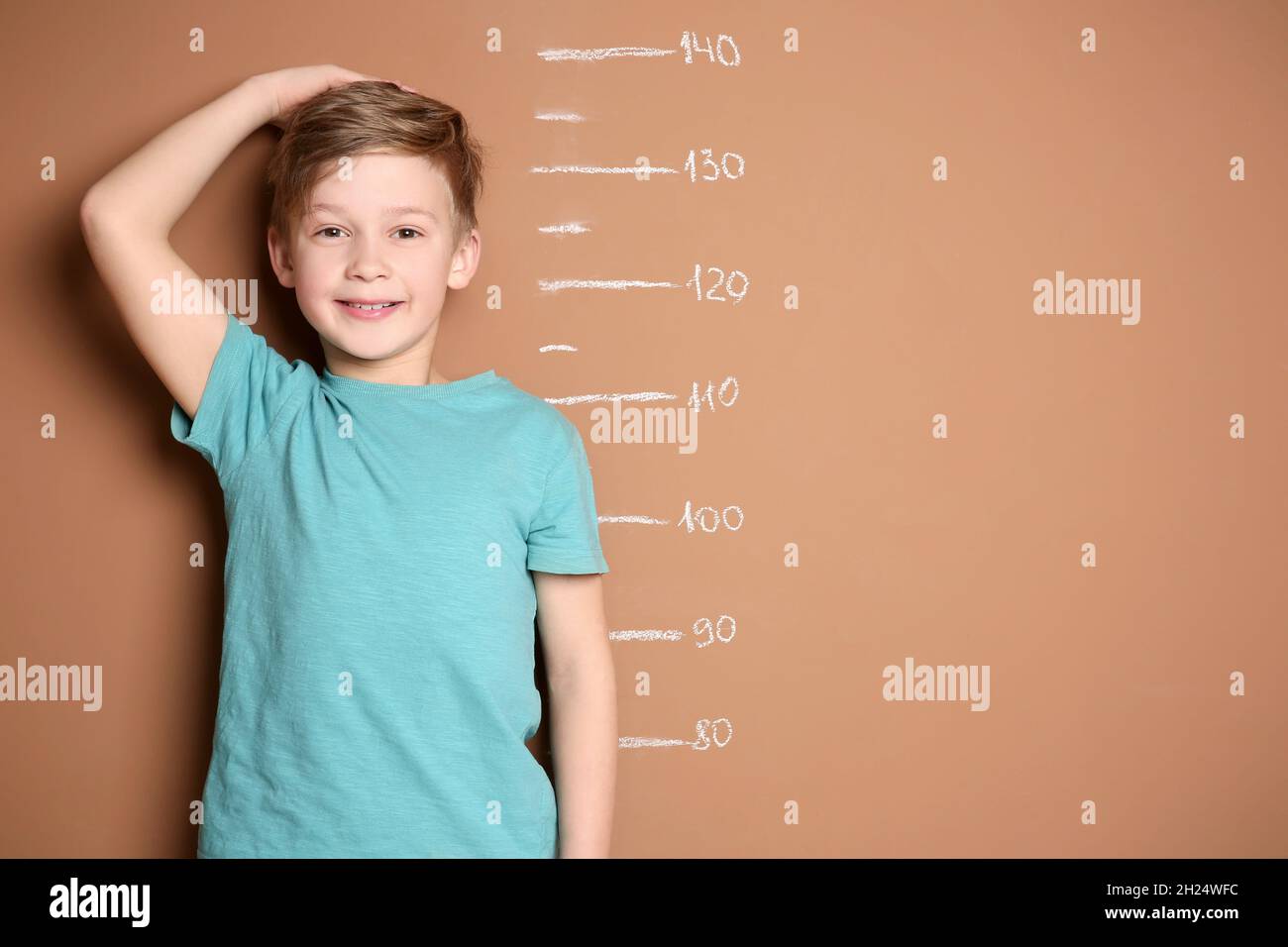 Little boy measuring his height on color background Stock Photo - Alamy