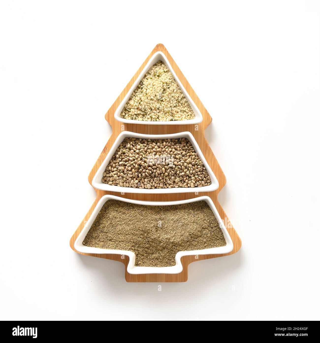 Hemp seeds, flour, kernels in plate shape of Christmas tree isolated on ...
