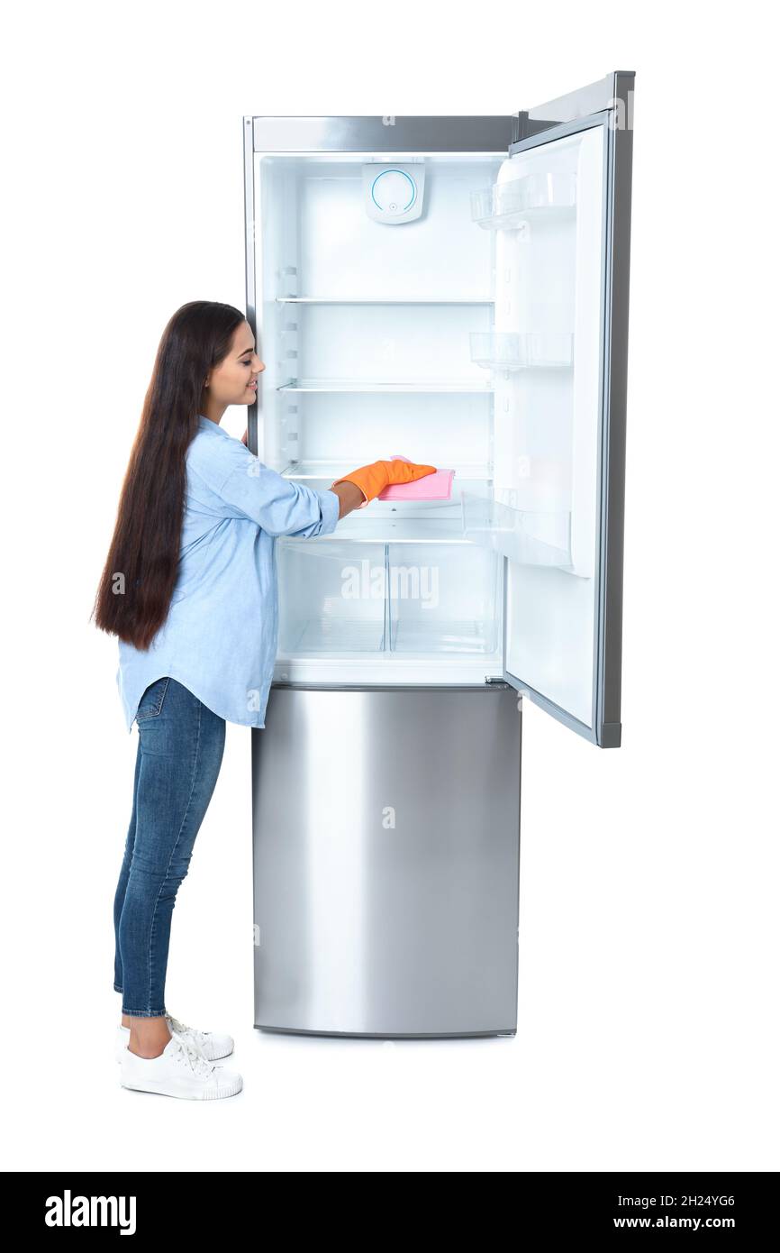 Young woman cleaning refrigerator with rag on white background Stock ...