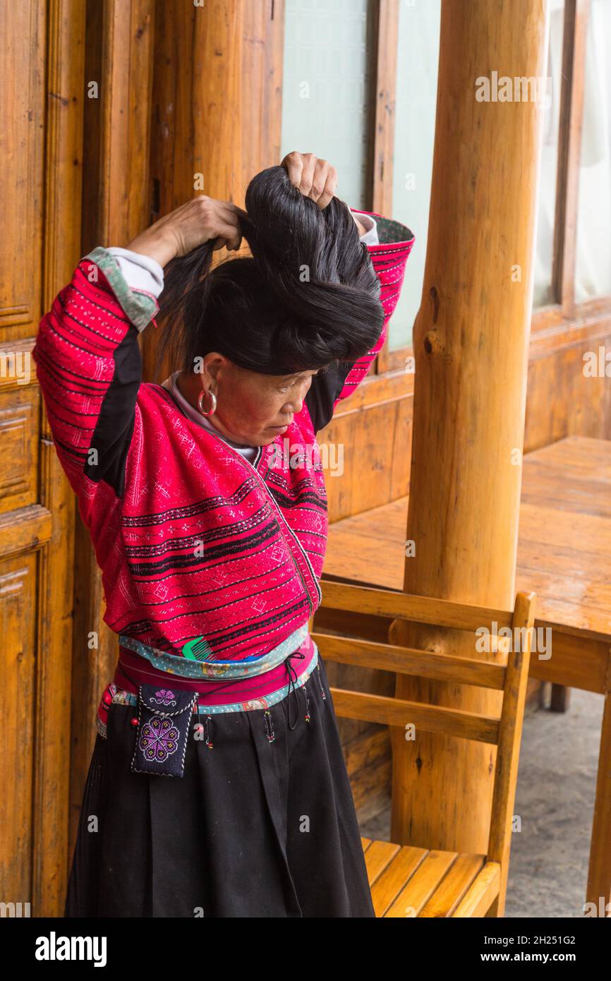 A woman of the Red Yao ethnic minority fixes her traditional long hair ...