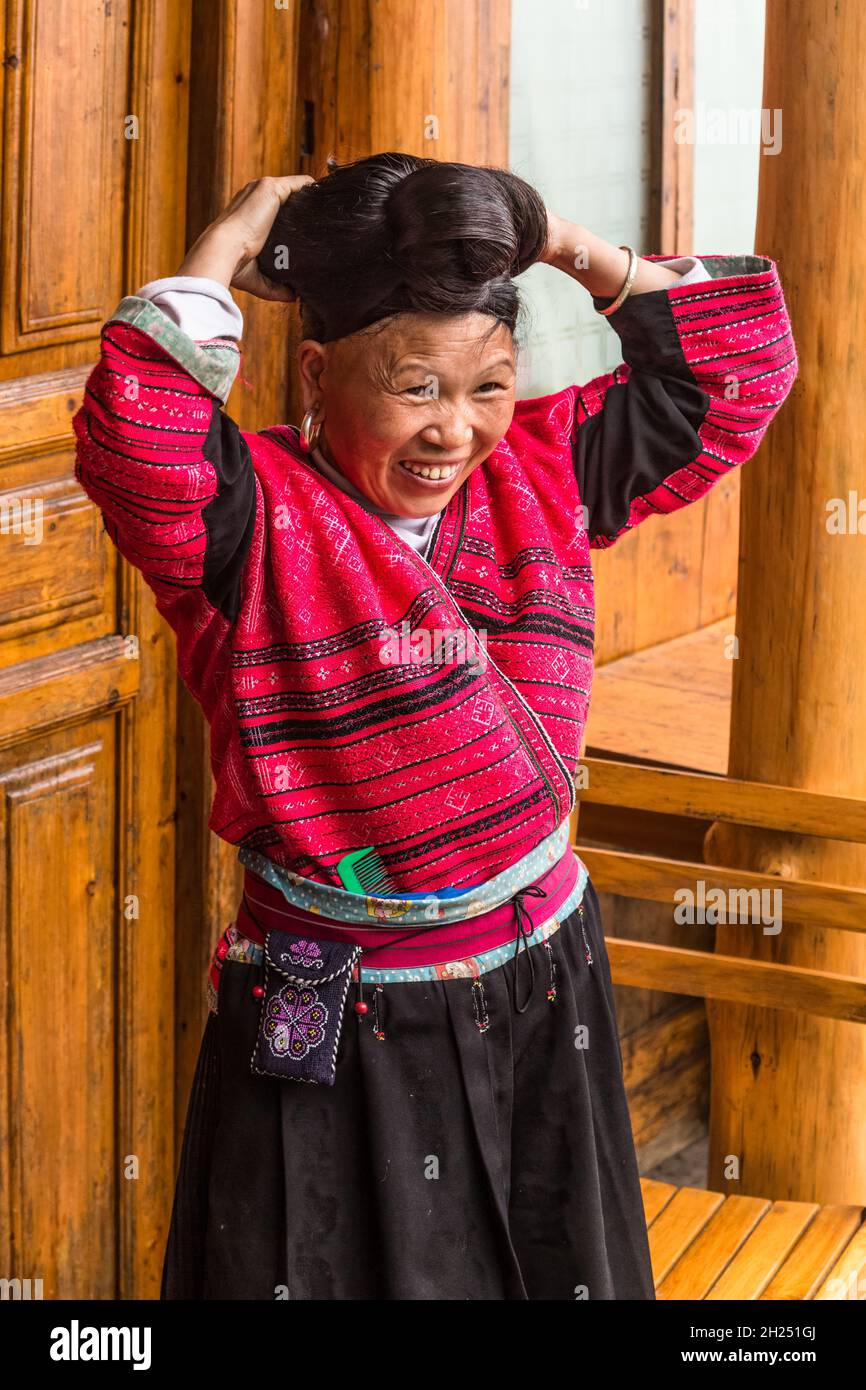 A woman of the Red Yao ethnic minority fixes her traditional long hair ...