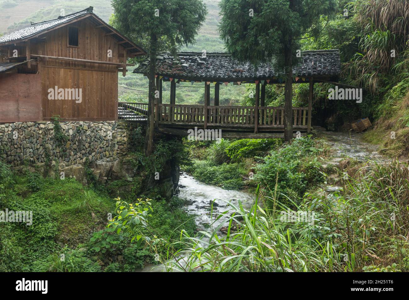 A covered bridge over a stream in the Jinkeng Rice Terraces in Longshen ...