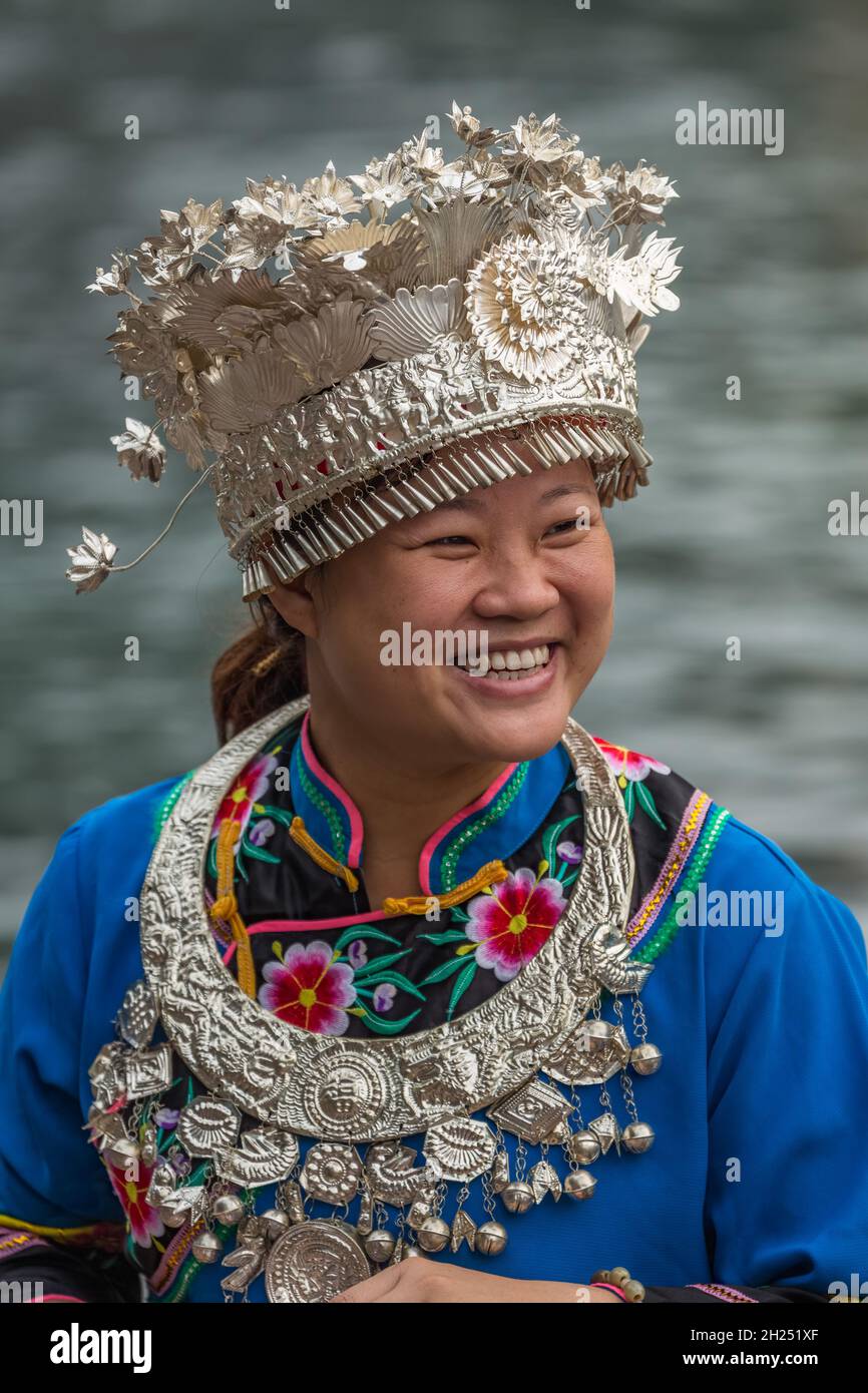 A young woman poses in the traditional ceremonial dress of the MIao ...