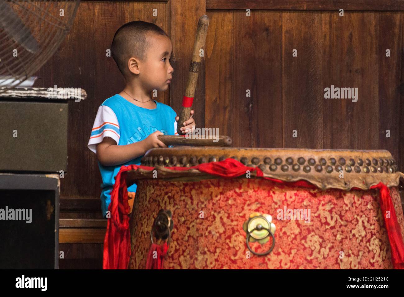 A young Yao boy beats a traditional drum before a cultural performance ...