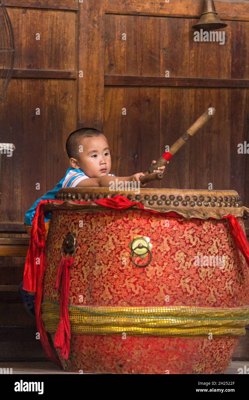 A young Yao boy beats a traditional drum before a cultural performance ...