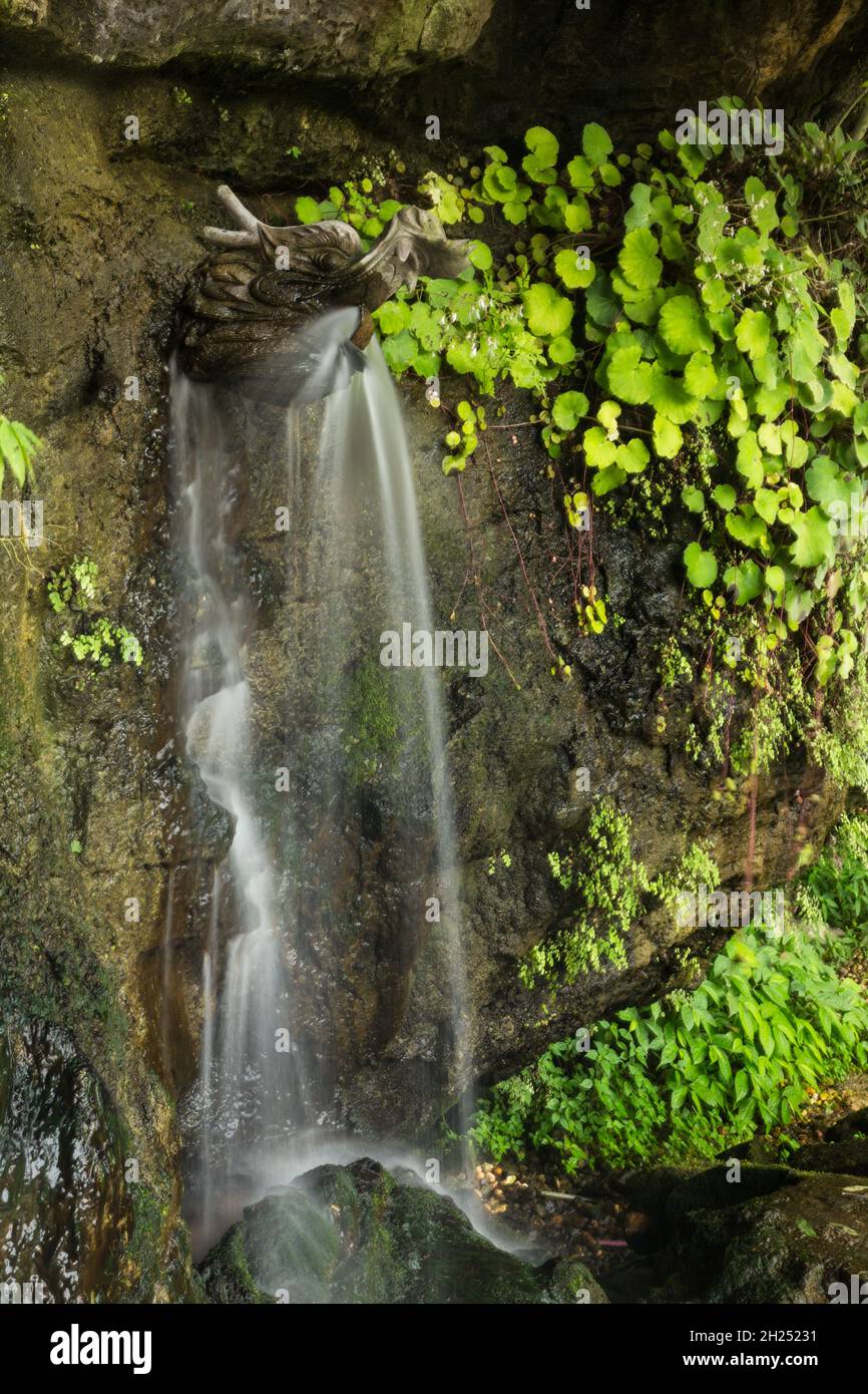 Water spewing from the mouth of a bronze dragon head beneath the ...
