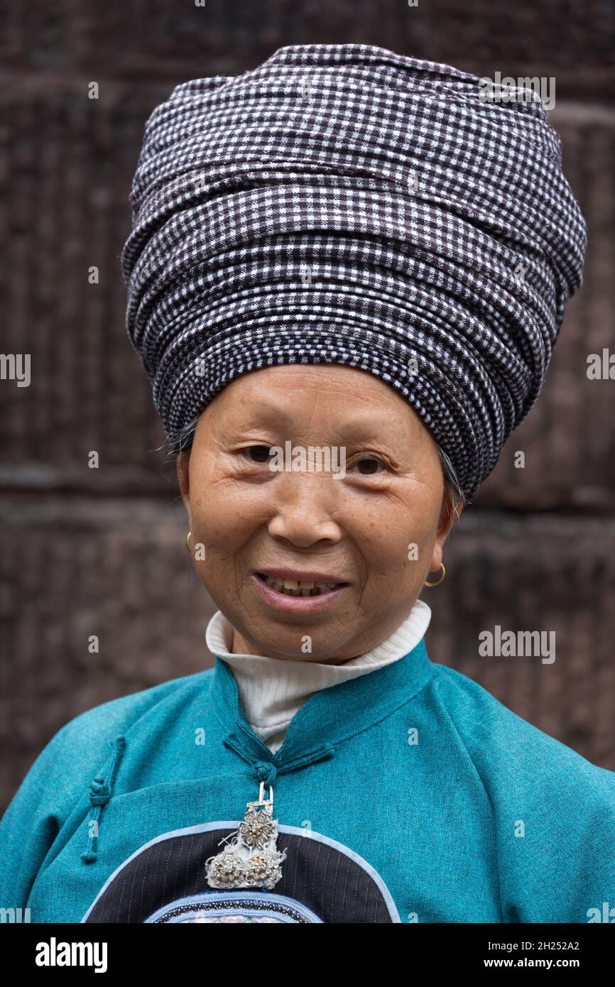 A woman in the traditional attire of the Tujia ethnic minority in ...