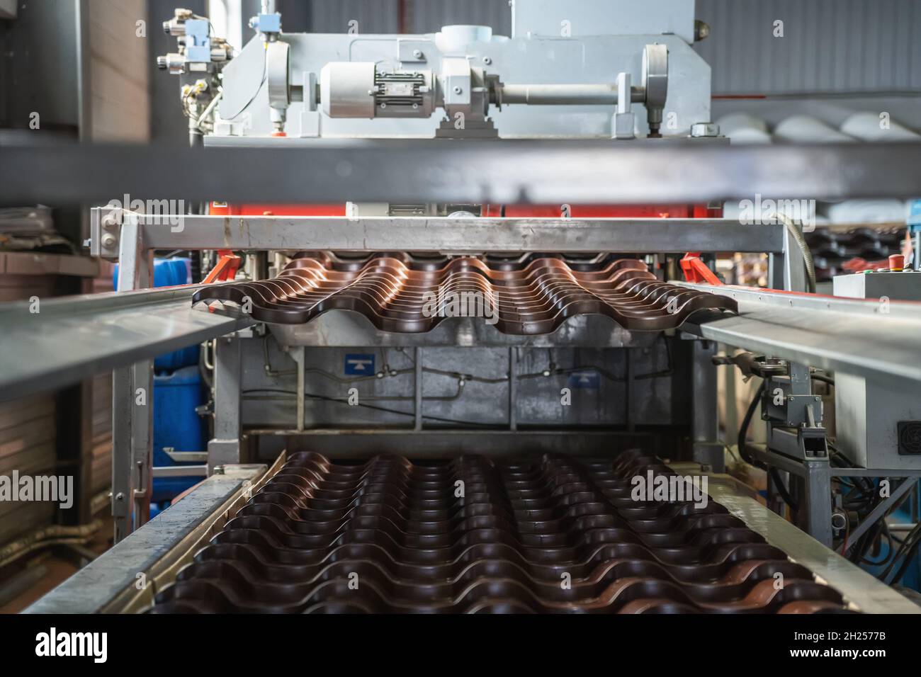 Metal tile for roof in metal forming machine production line close up ...