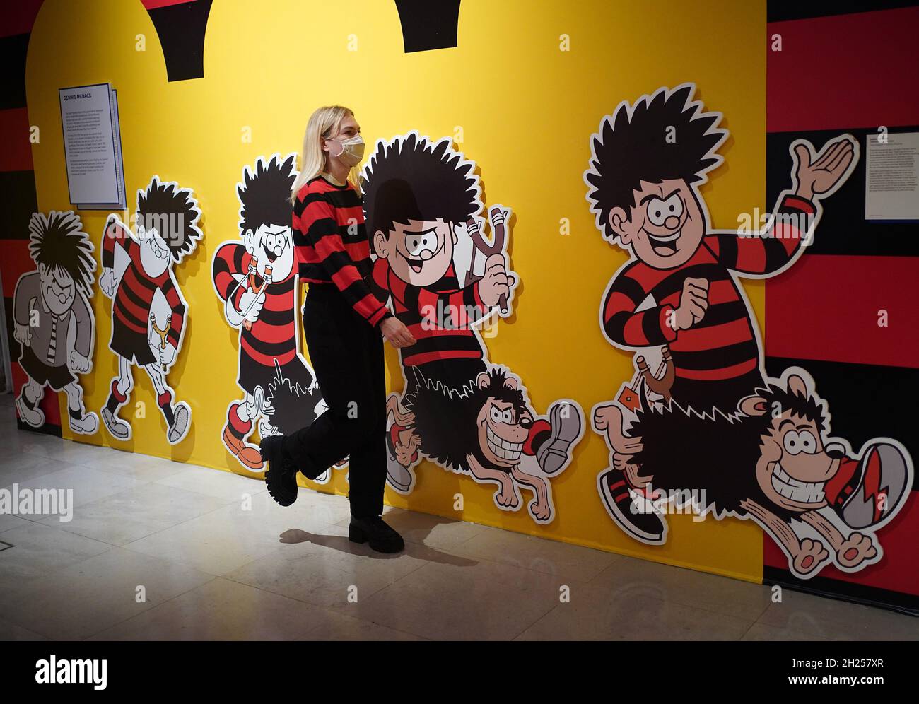 Gallery staff Abi Francis poses next to a montage by artist and curator ...