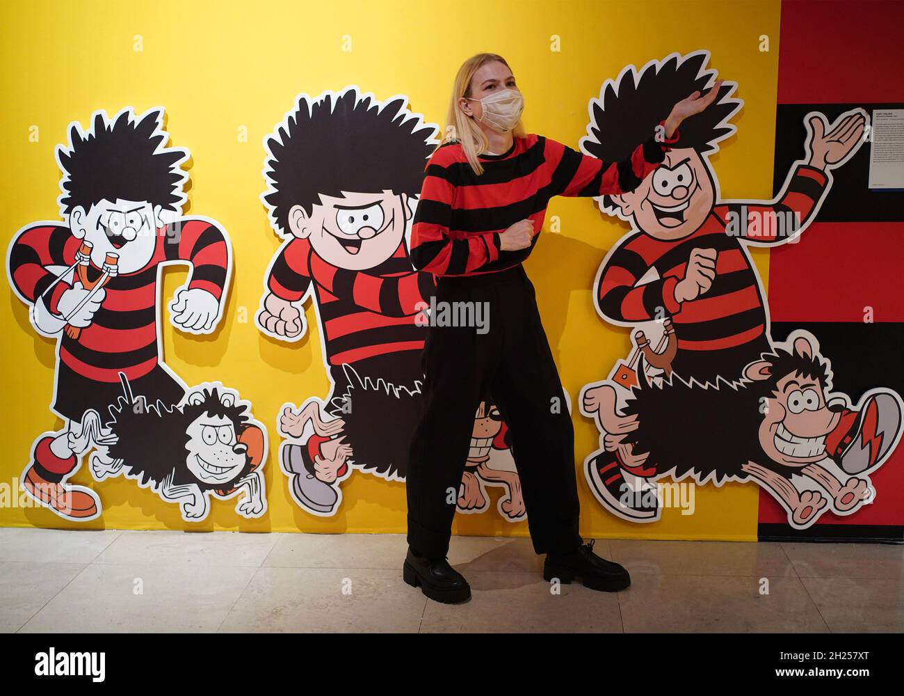 Gallery staff Abi Francis poses next to a montage by artist and curator ...