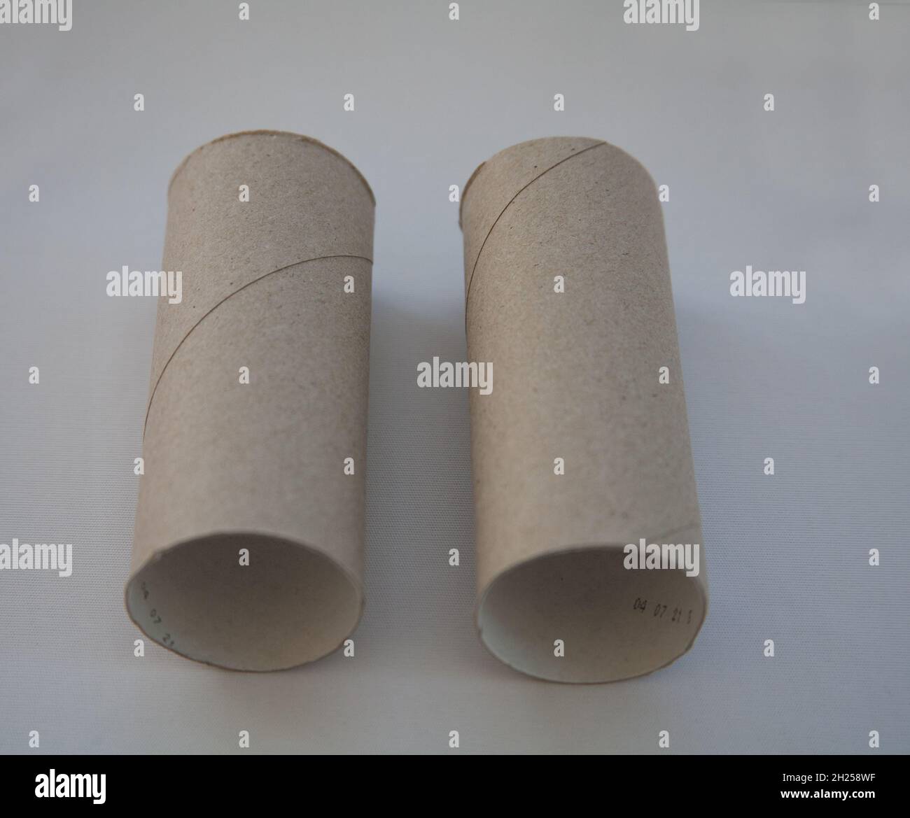 Close up two cardboard inserts from used toilets rolls empty shelves ...